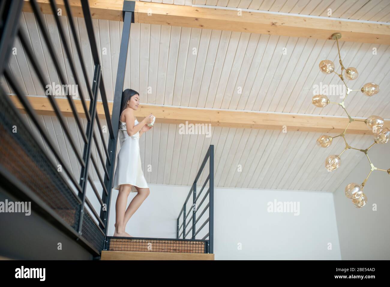 Woman standing on top of stairs hi-res stock photography and images - Alamy