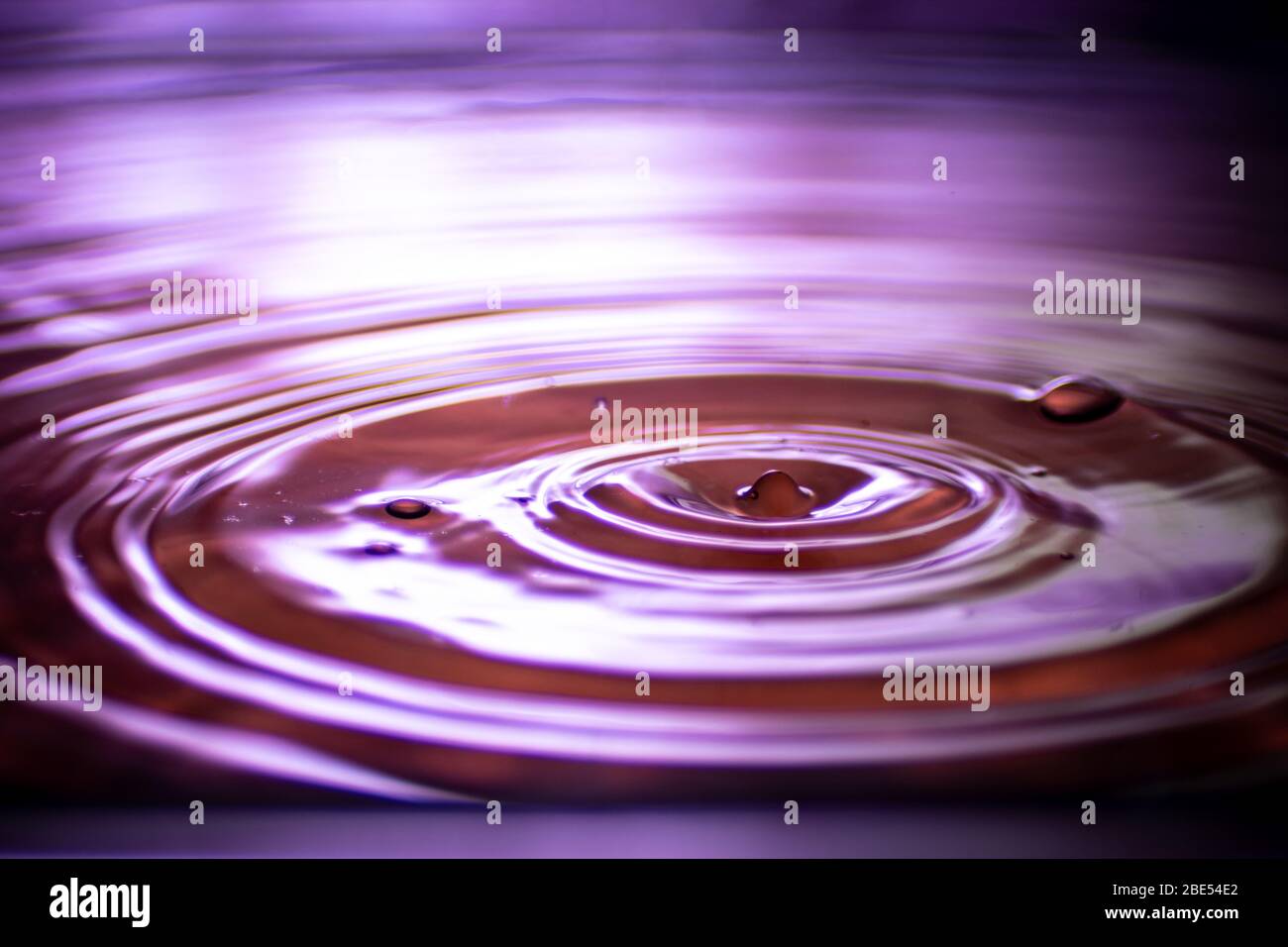 purple splash in to the water Stock Photo - Alamy