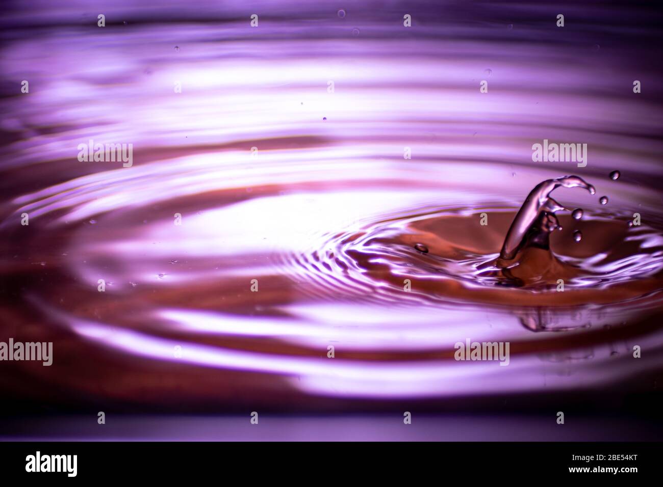 purple splash in to the water Stock Photo - Alamy
