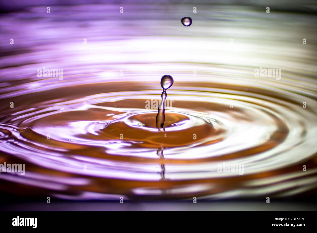 purple splash in to the water Stock Photo - Alamy