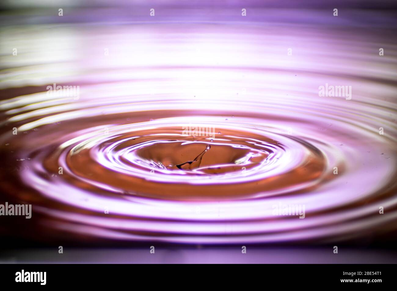 purple splash in to the water Stock Photo - Alamy