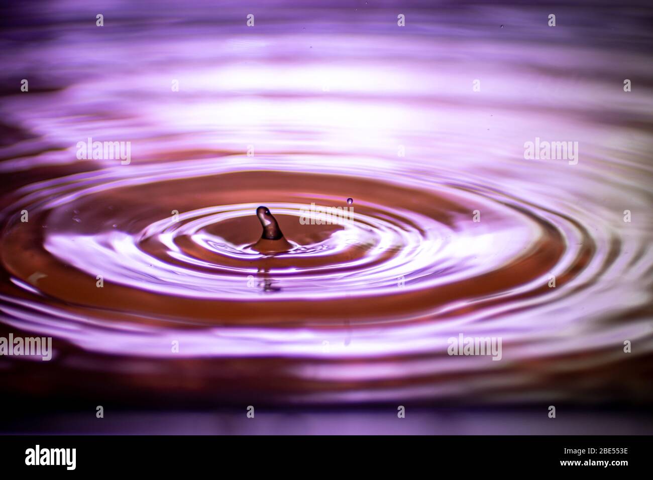 purple splash in to the water Stock Photo - Alamy