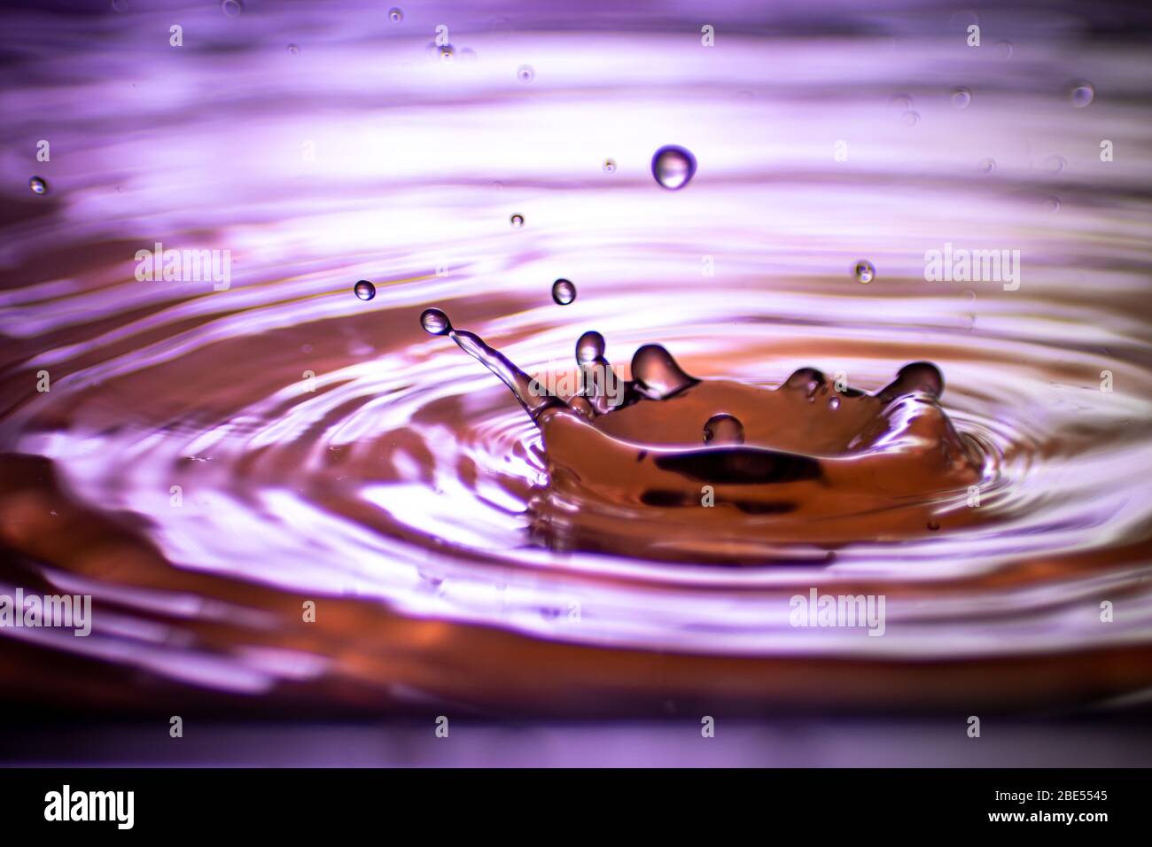 purple splash in to the water Stock Photo - Alamy