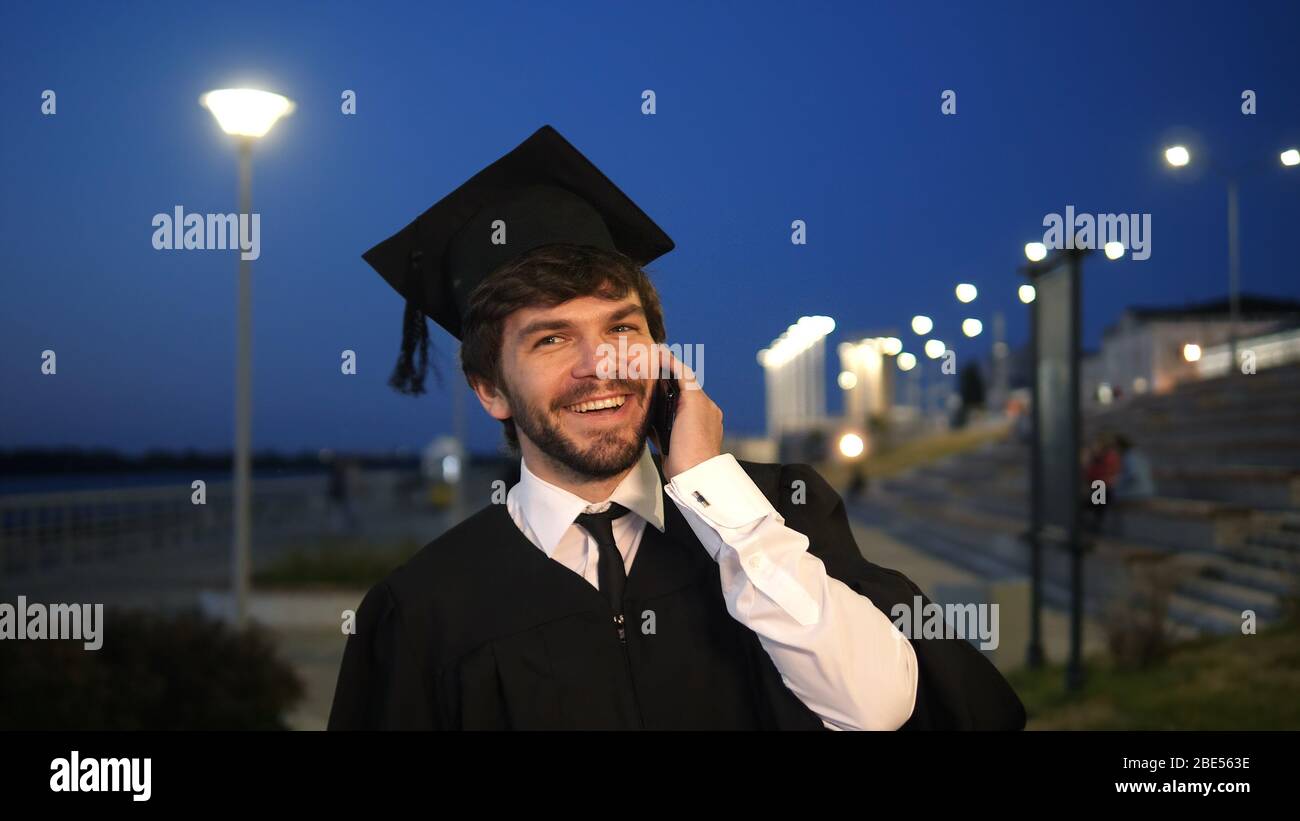 Graduate student walking and making a call Stock Photo - Alamy