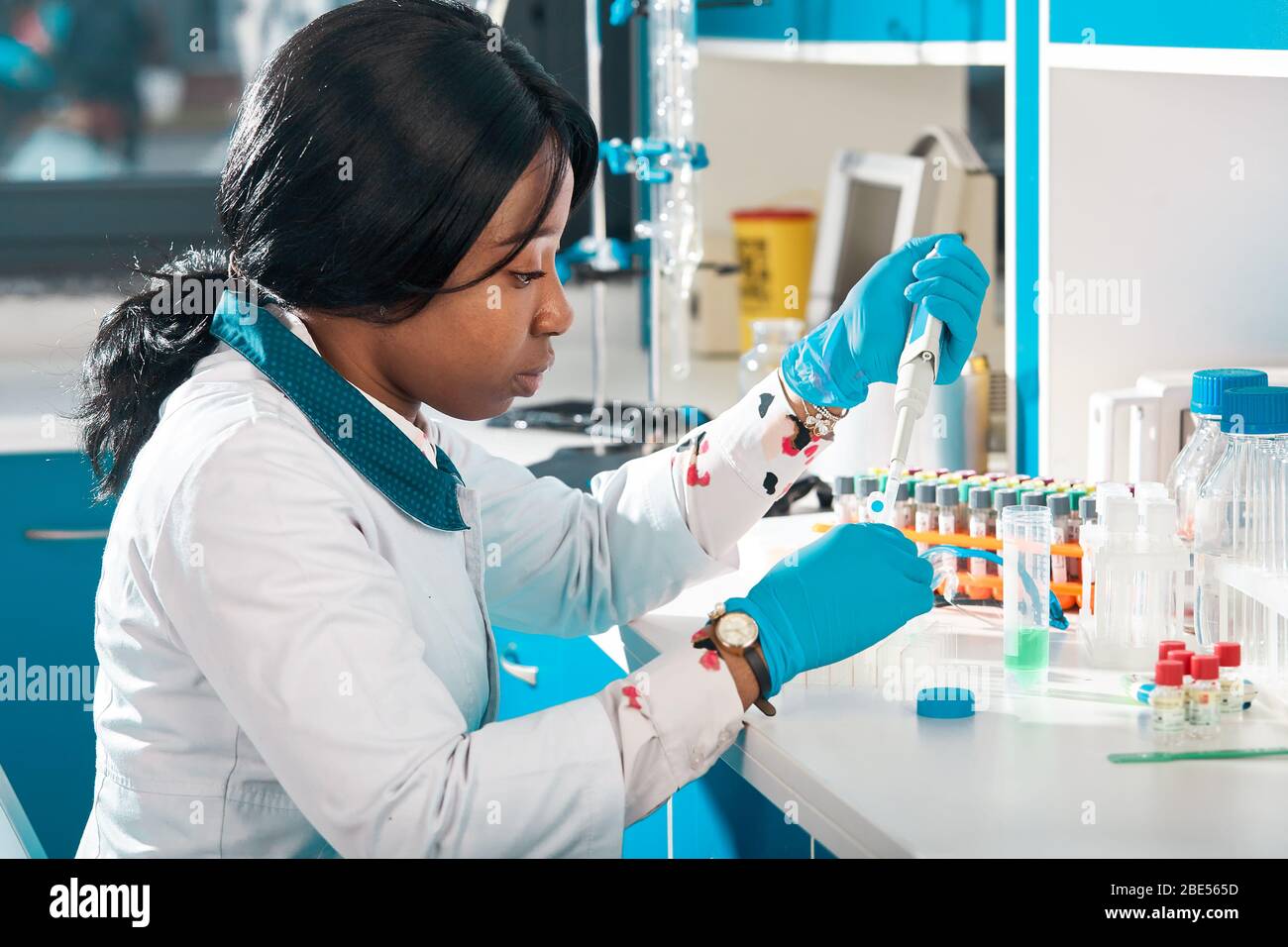 African scientist or graduate student in lab coat and protective wear ...