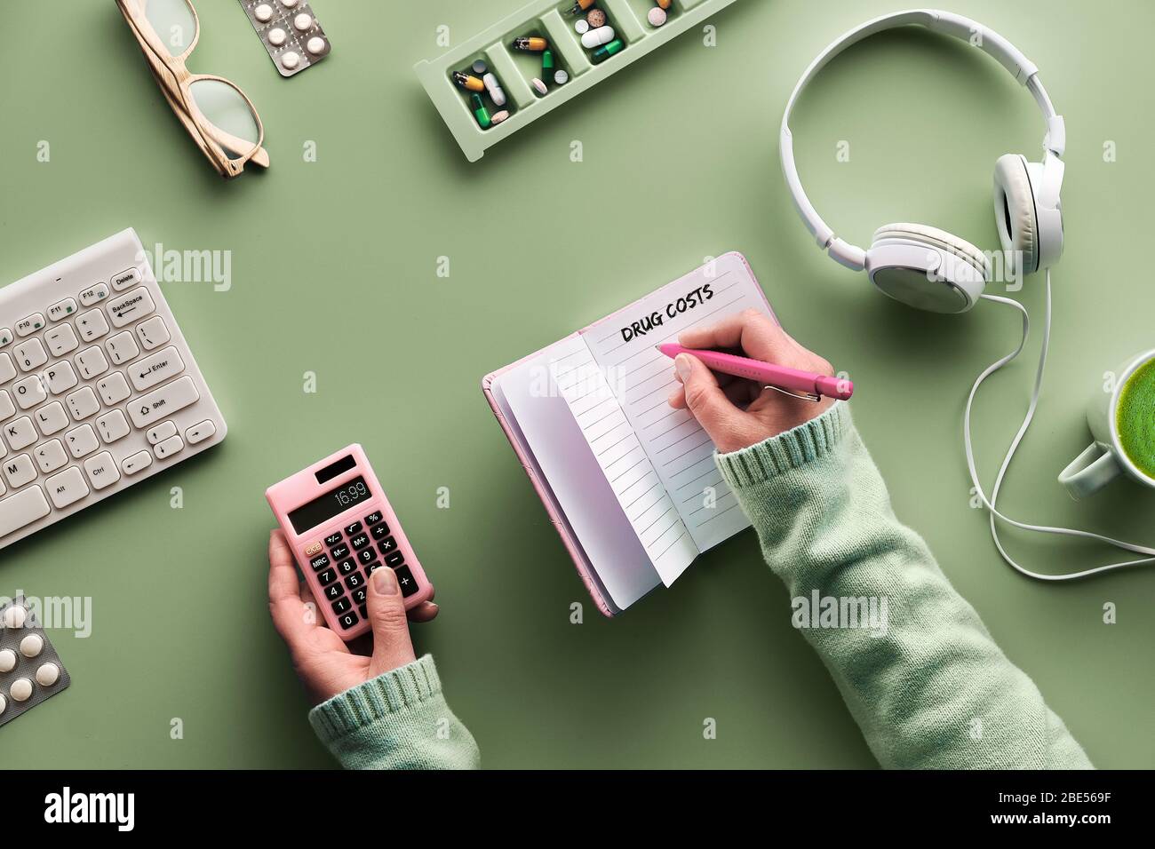 Flat lay with notebook to monitor drug costs. Hands with pen and ...