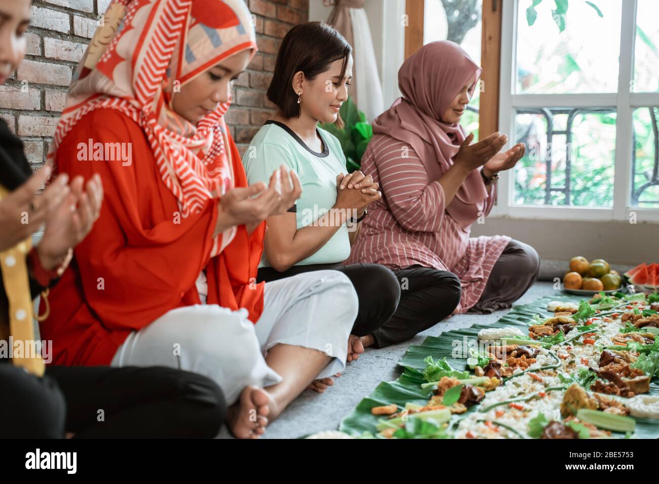 asian woman praying. diverse religion friends eating together at home ...