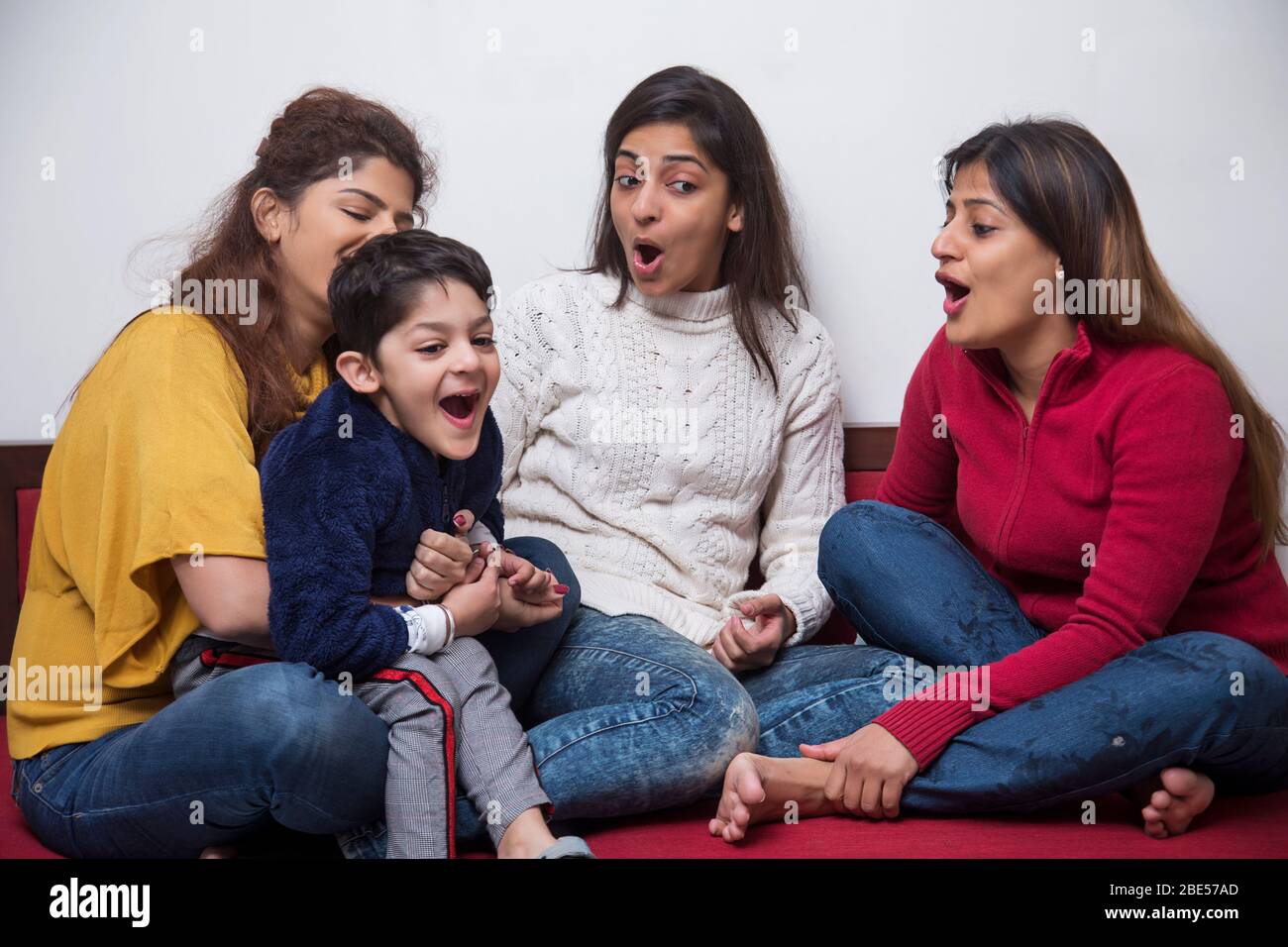 Young boy having fun with their aunts at home Stock Photo - Alamy