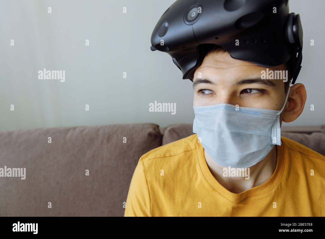 The man is sitting in virtual reality glasses and masks on self ...