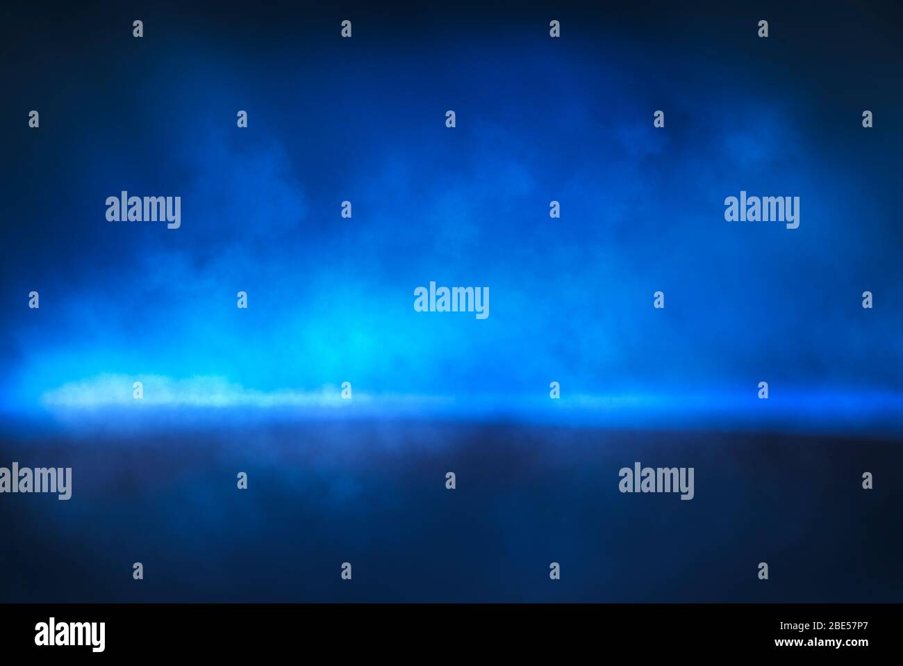 Abstract blue mist studio background. Smoke texture illuminated by ...