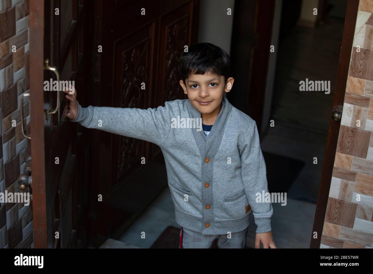 Young boy opening the door. (Children Stock Photo - Alamy