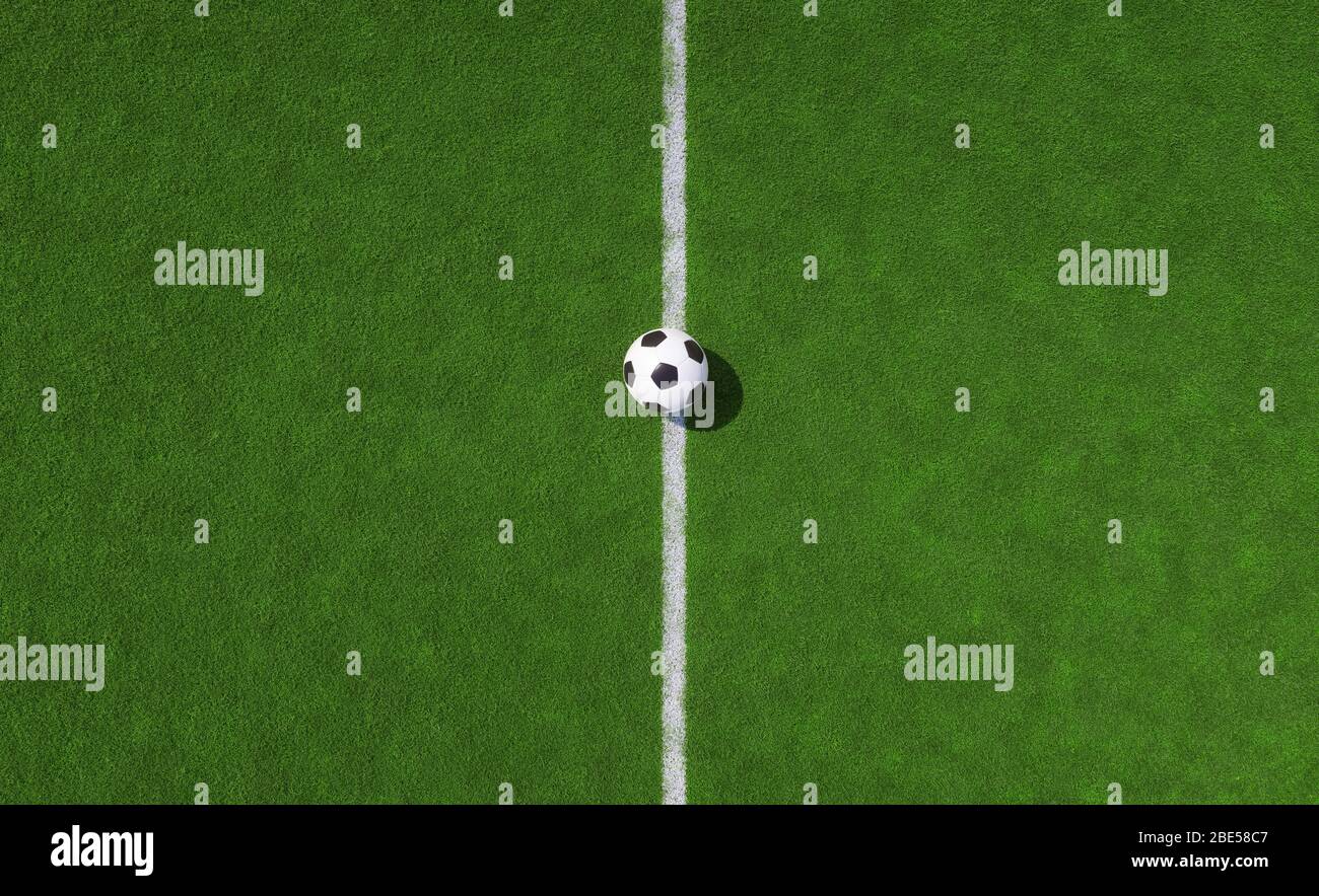 Football or soccer ball on a white center line on green turf on a ...