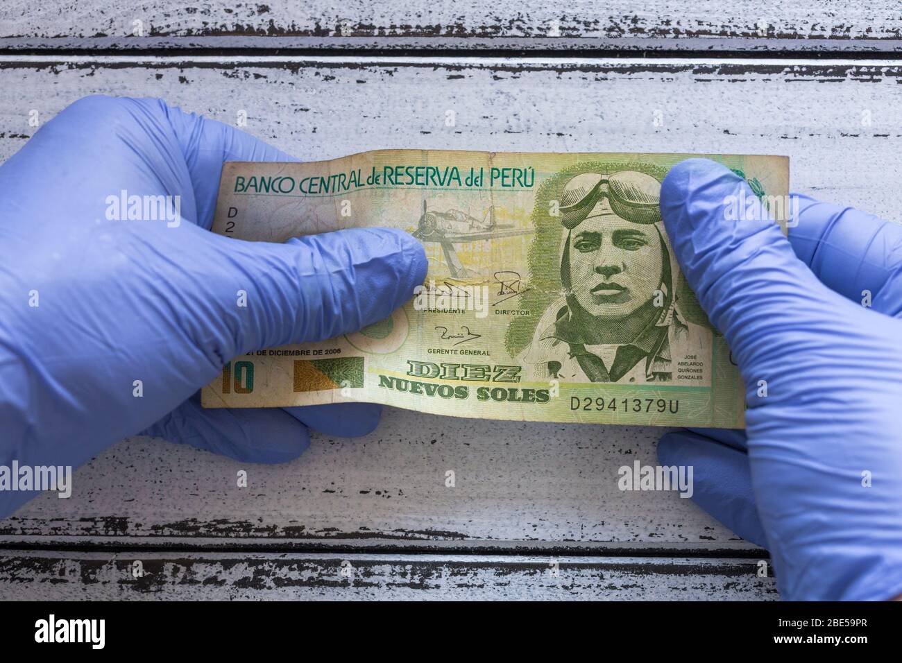 Peru money, ten Soles banknote kept in rubber gloves. The concept of ...