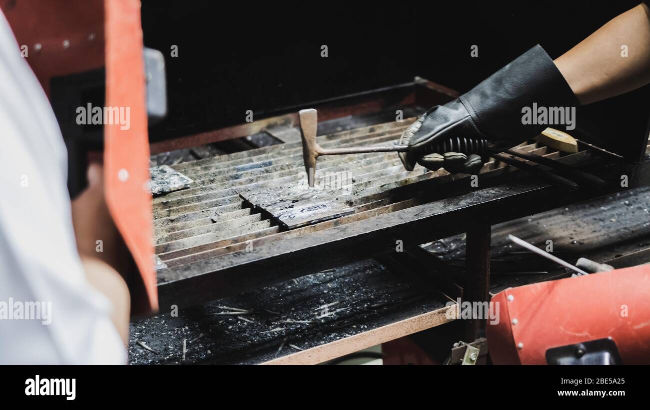 Worker using metal hammer to hit the steel after welding. Other ...