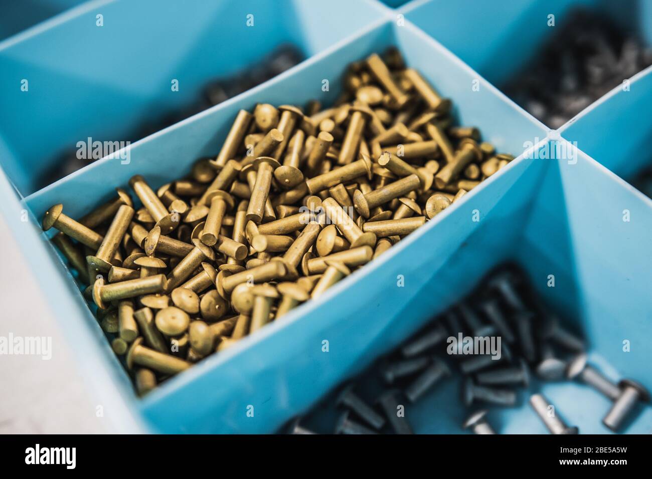 Bunch of golden and silver aircraft rivets used to repair aircraft ...