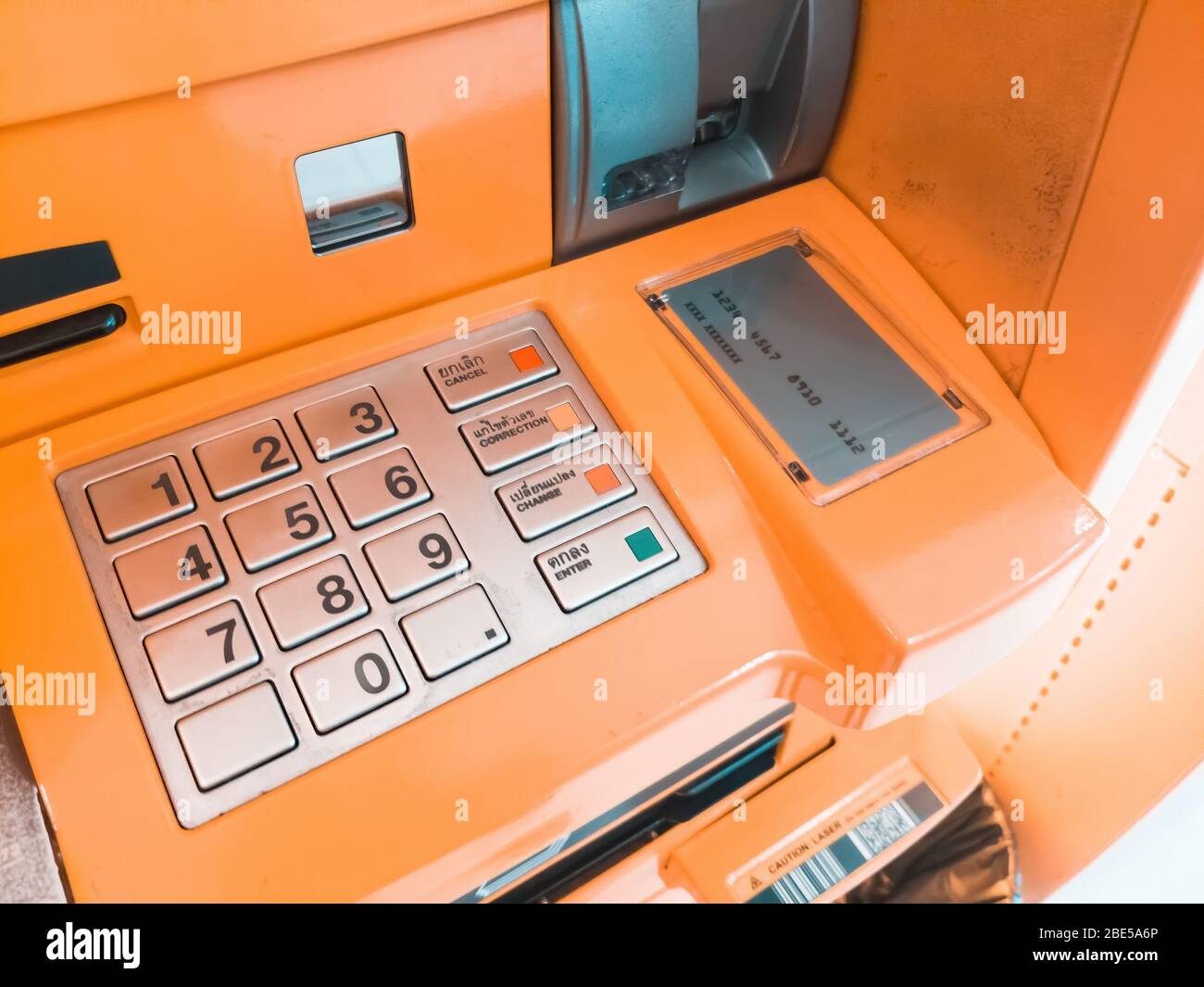 Close up of a keypad installed in a yellow ATM machine with button say ...