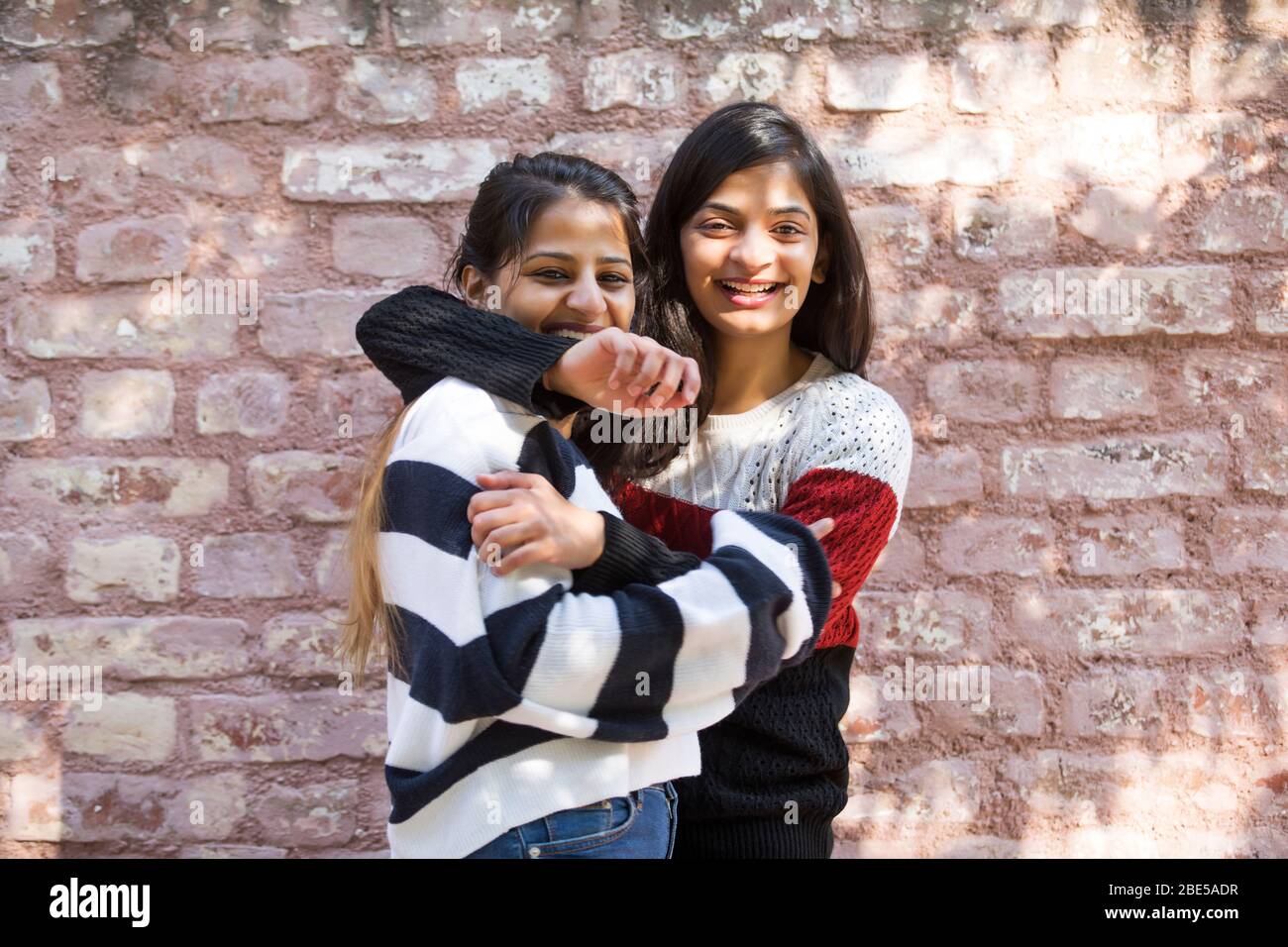 Sisters hugging each other outside Stock Photo - Alamy