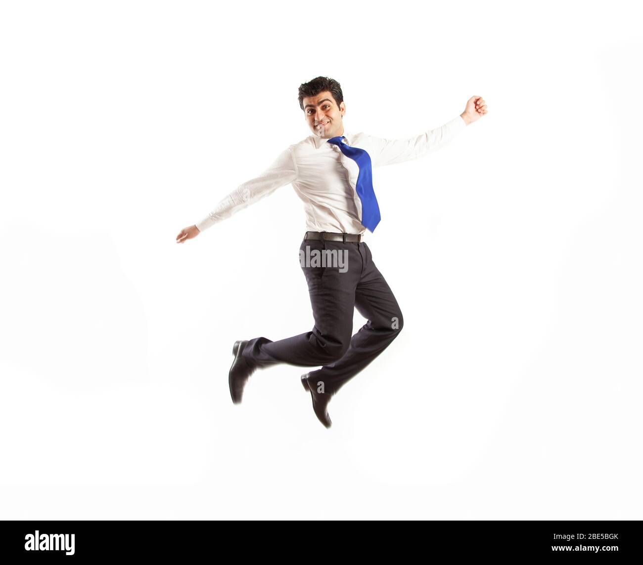 Young office corporate man jumping high spreading his arms with joy ...