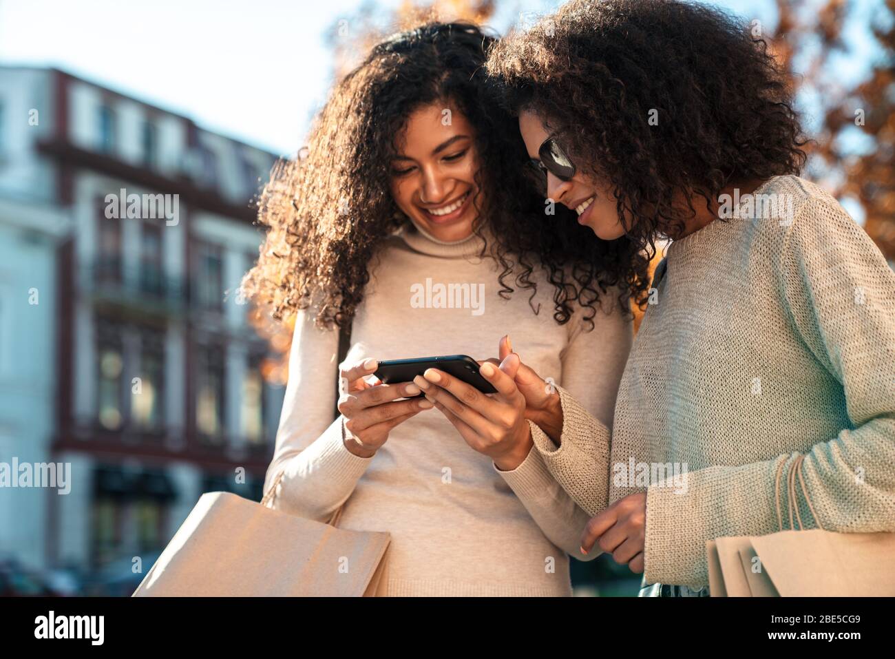 Two beautiful young stylish african women walking together at the ...
