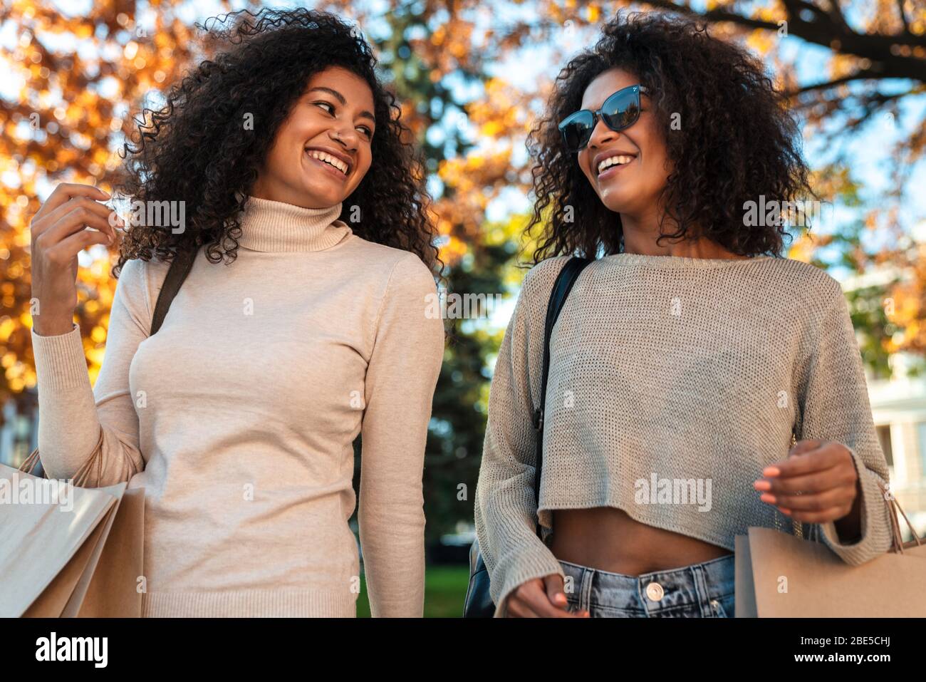 Two beautiful young stylish african women walking together at the ...