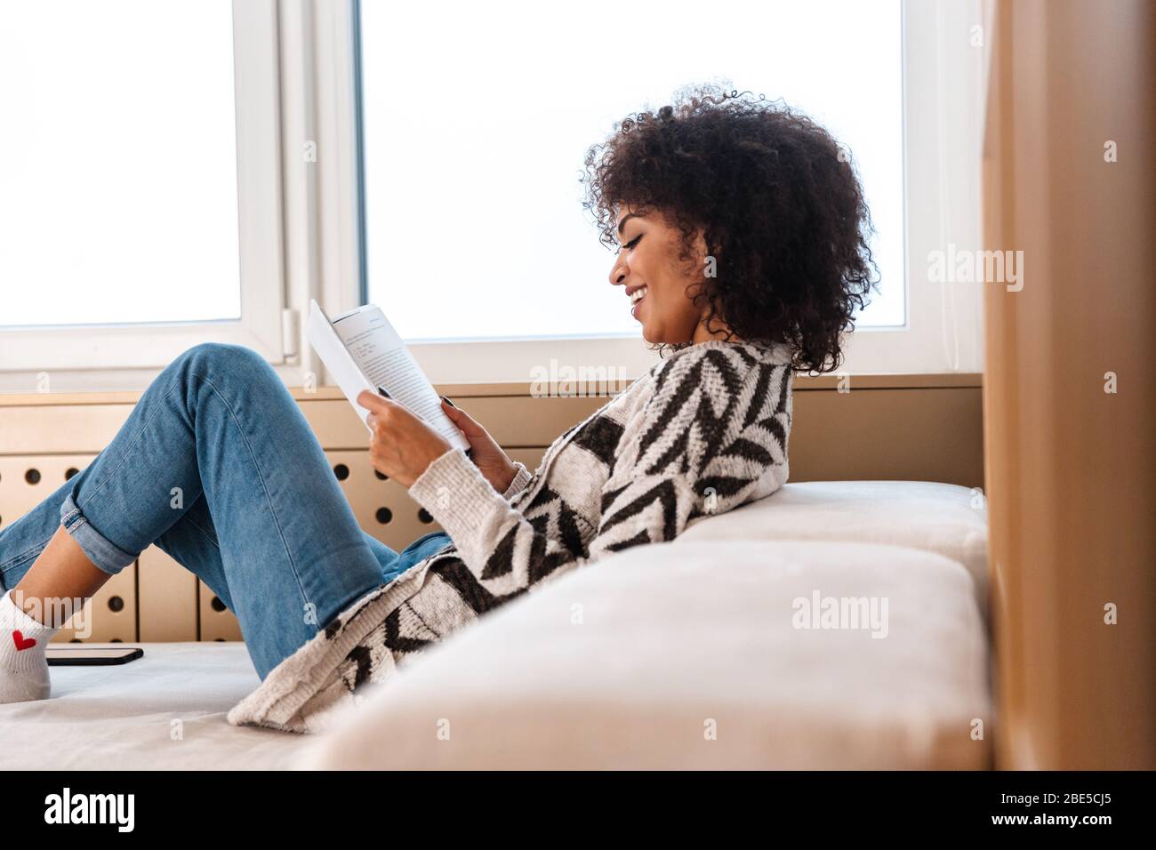 Image of amazing laughing pretty young african woman indoors at home ...