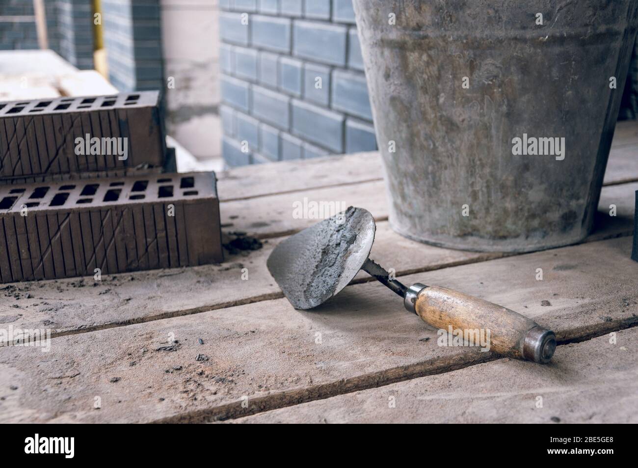 A mason tool by a stern plan in the workplace. Trowel for bricklaying ...