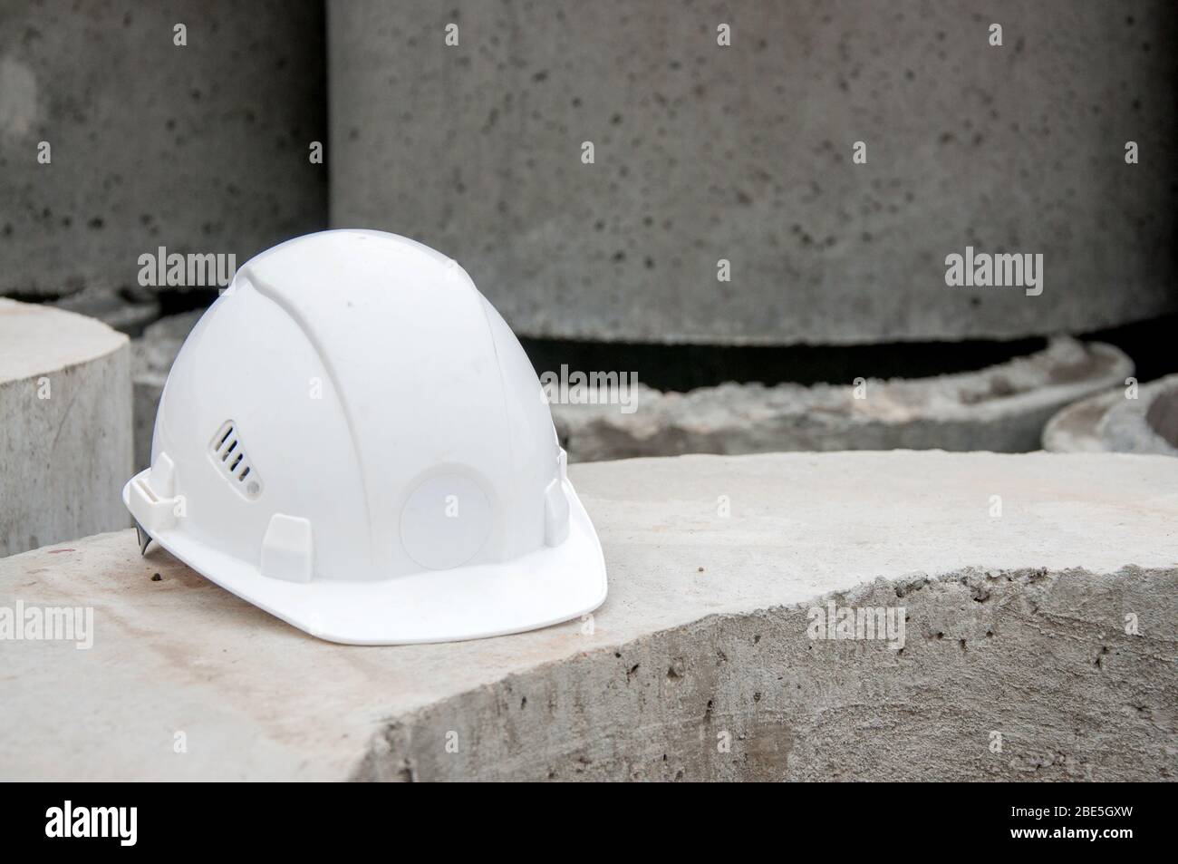 Construction helmet white on the background of concrete products ...