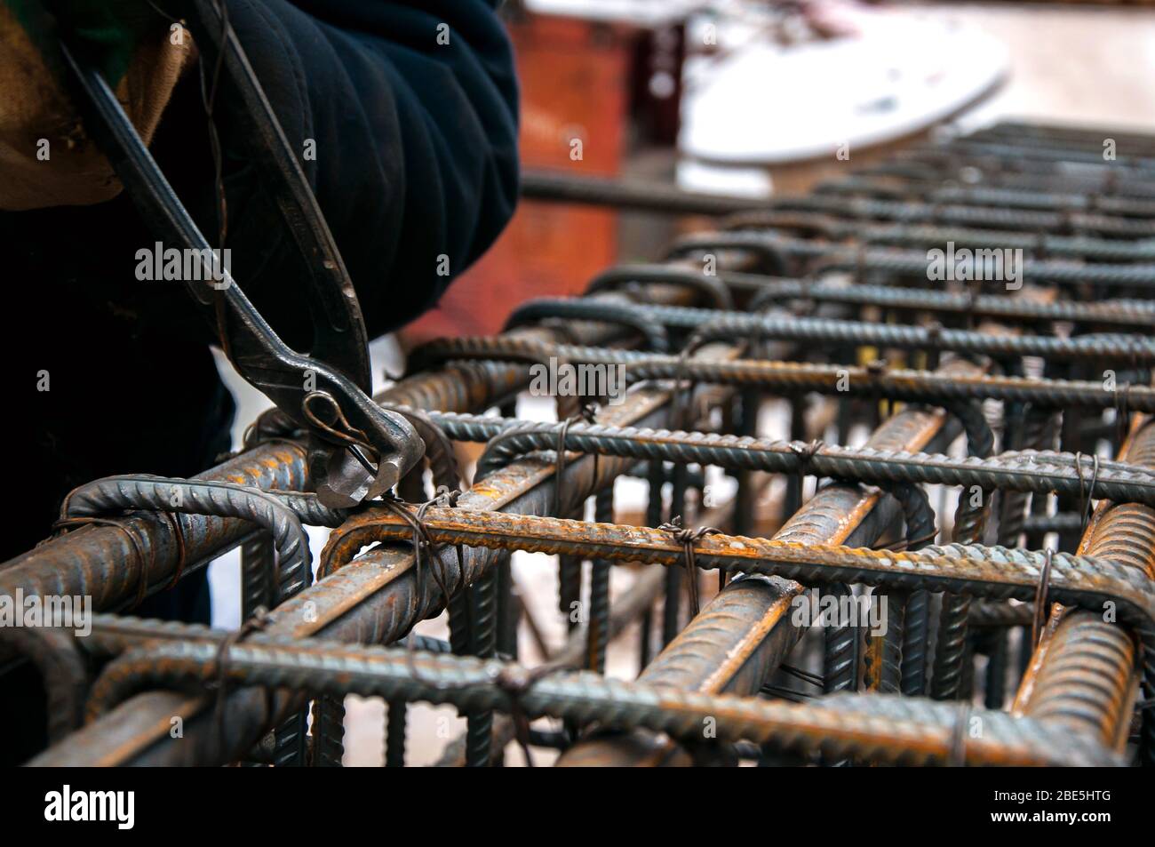 Attaching the rebars to each other. Worker's hands fasten the ...