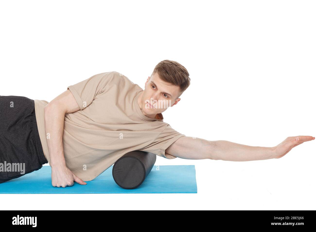 Handsome man shows exercises using a foam roller for a myofascial ...