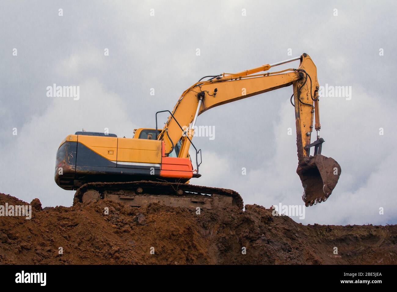 The construction site excavator digs a deep pit. Digger. Construction ...