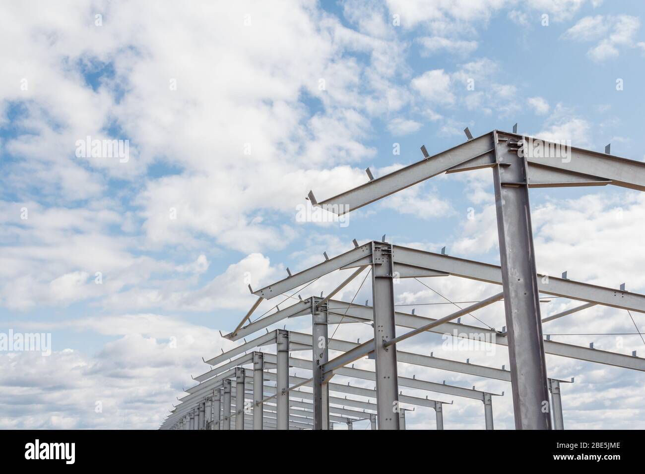 Steel beam structure on new building against the blue sky with clouds ...