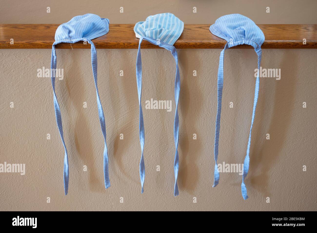 A close-up of three, hand-sewn face masks that were made from blue ...