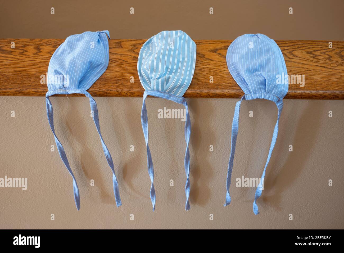 A close-up of three, hand-sewn face masks that were made from blue ...