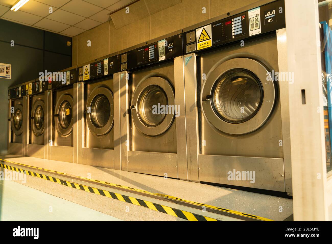 Washing machines in launderette Stock Photo - Alamy