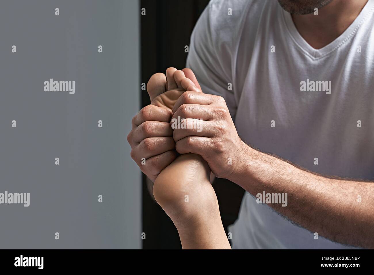 Male Masseur Hands Doing Reflexology Massage On Female Foot Reflex