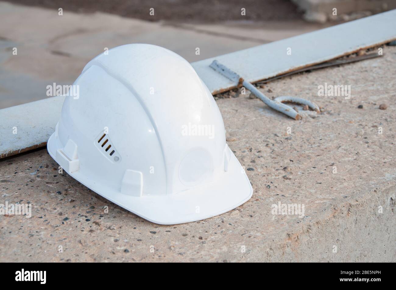 White construction hat on a concrete slab. Headpiece for protection ...