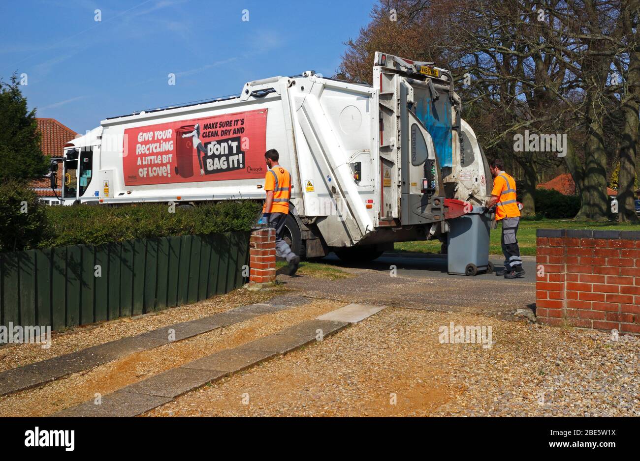 Binmen at work collecting and emptying recycling bins in a residential ...
