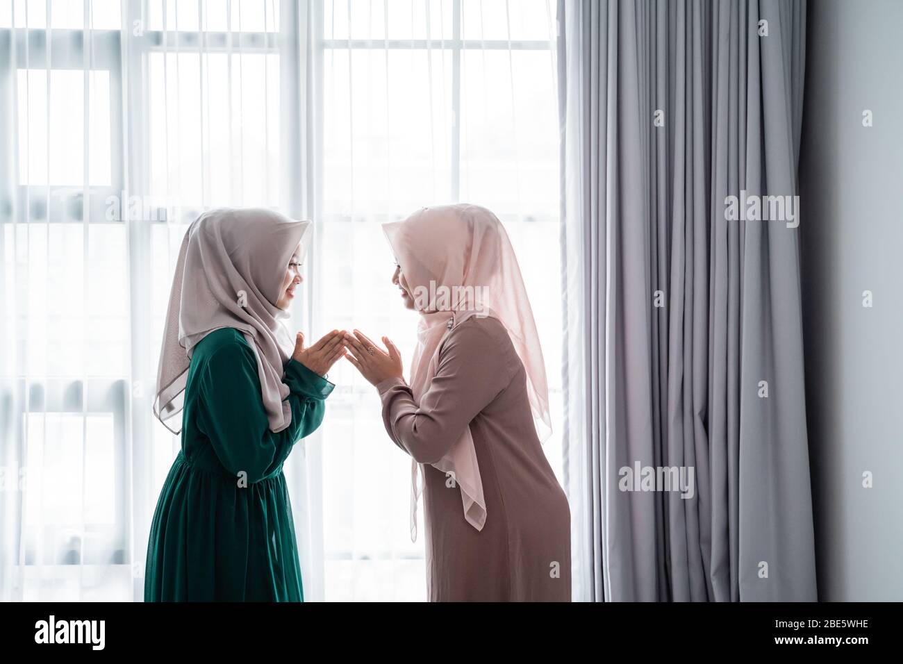 asian muslim woman say salam when meeting her friend when she enters ...
