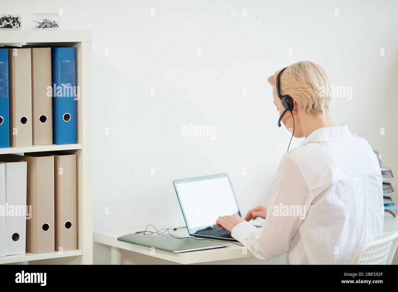 Back view portrait of modern businesswoman wearing headset while ...