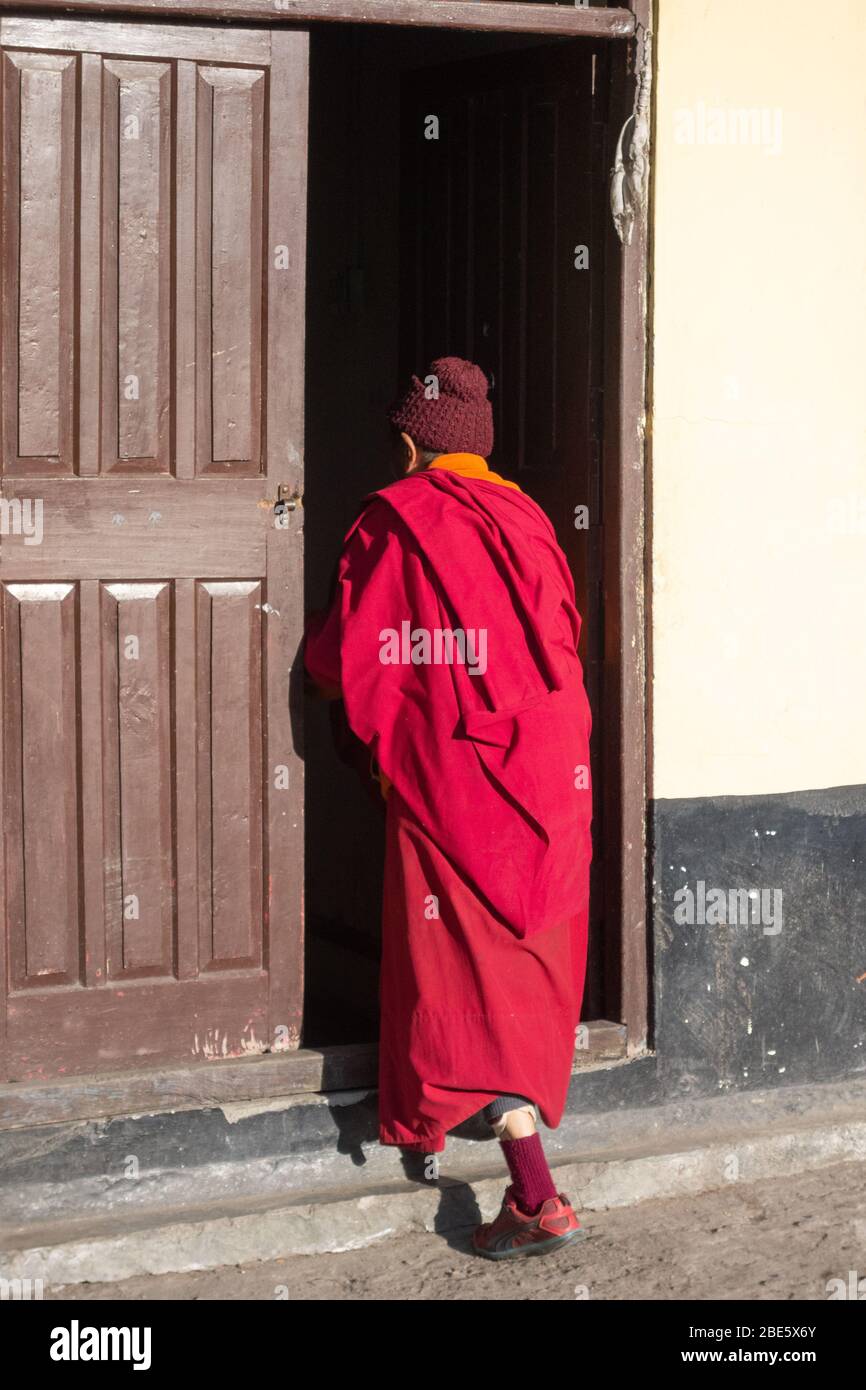 Buddhist monk entering a dark room at Rumtek Monastery in Sikkim, India ...