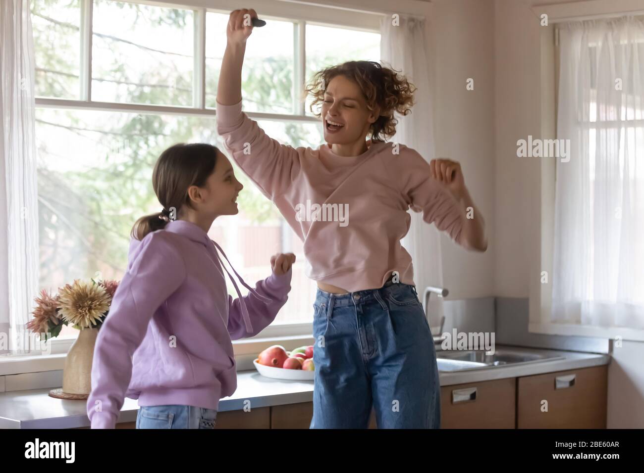 Funny mom and teen daughter dancing in kitchen cooking together Stock ...
