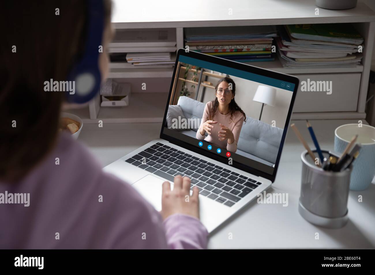 School girl student studying with online teacher on computer screen ...