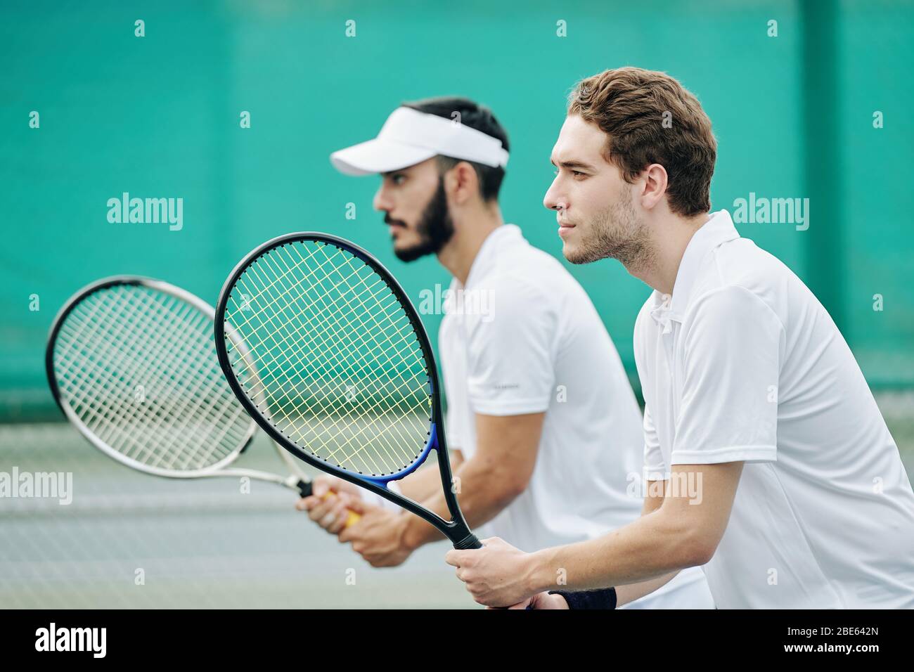Side view of serious concentrated tennis players with rackets ready to ...
