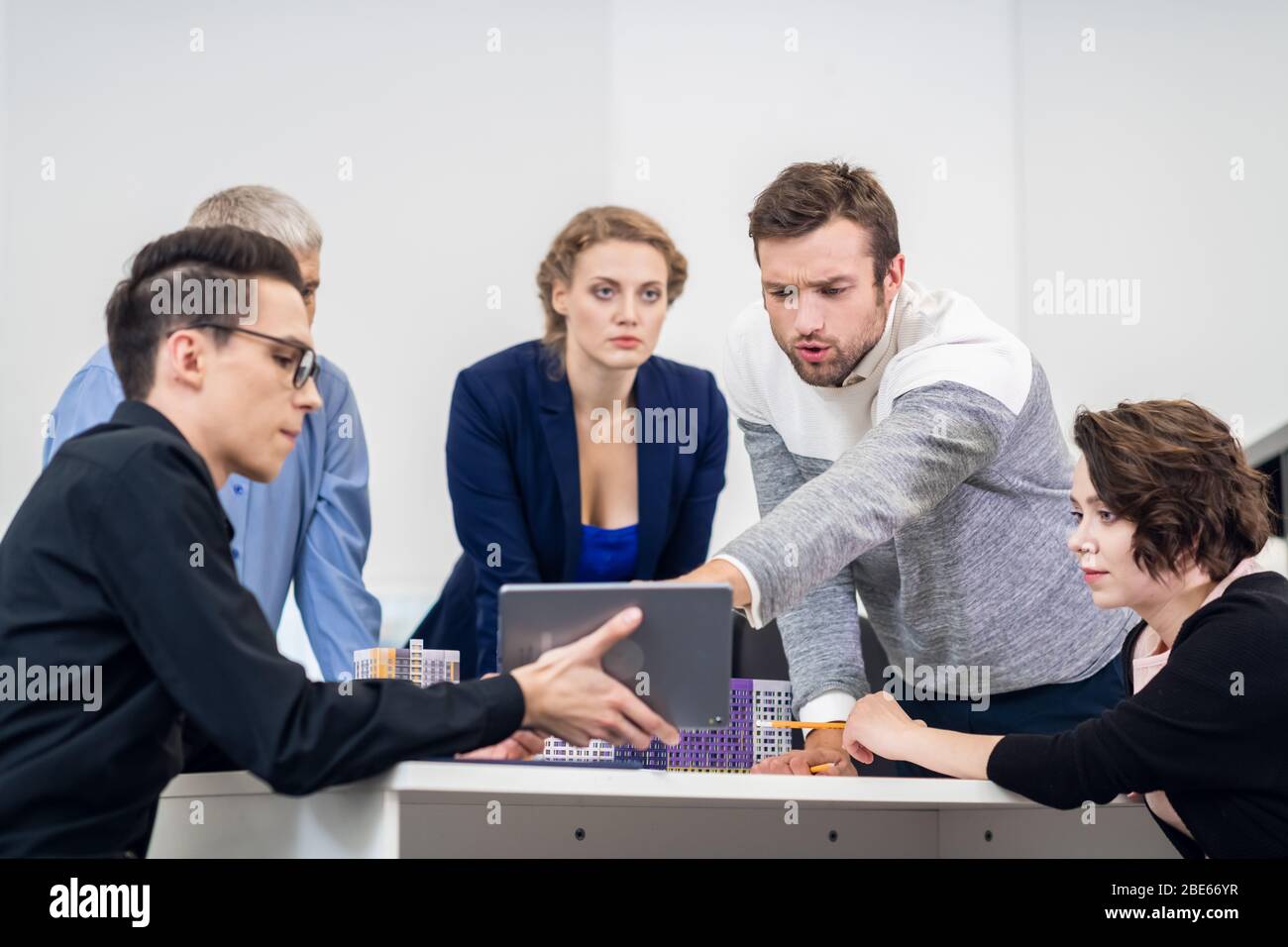 Young employee expressing his ideas to his colleagues on a meeting in ...