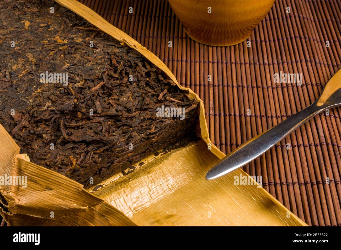 Chinese pressed PU-erh tea in bamboo leaf packaging and tea knife ...