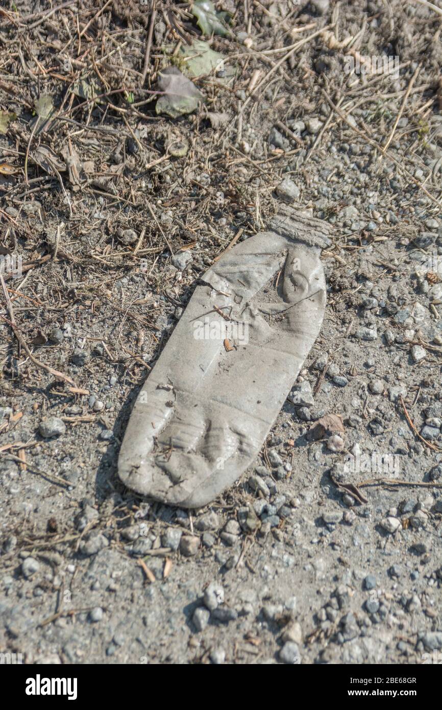 Empty soft drinks bottle on tarmac of quiet country road. Example of ...