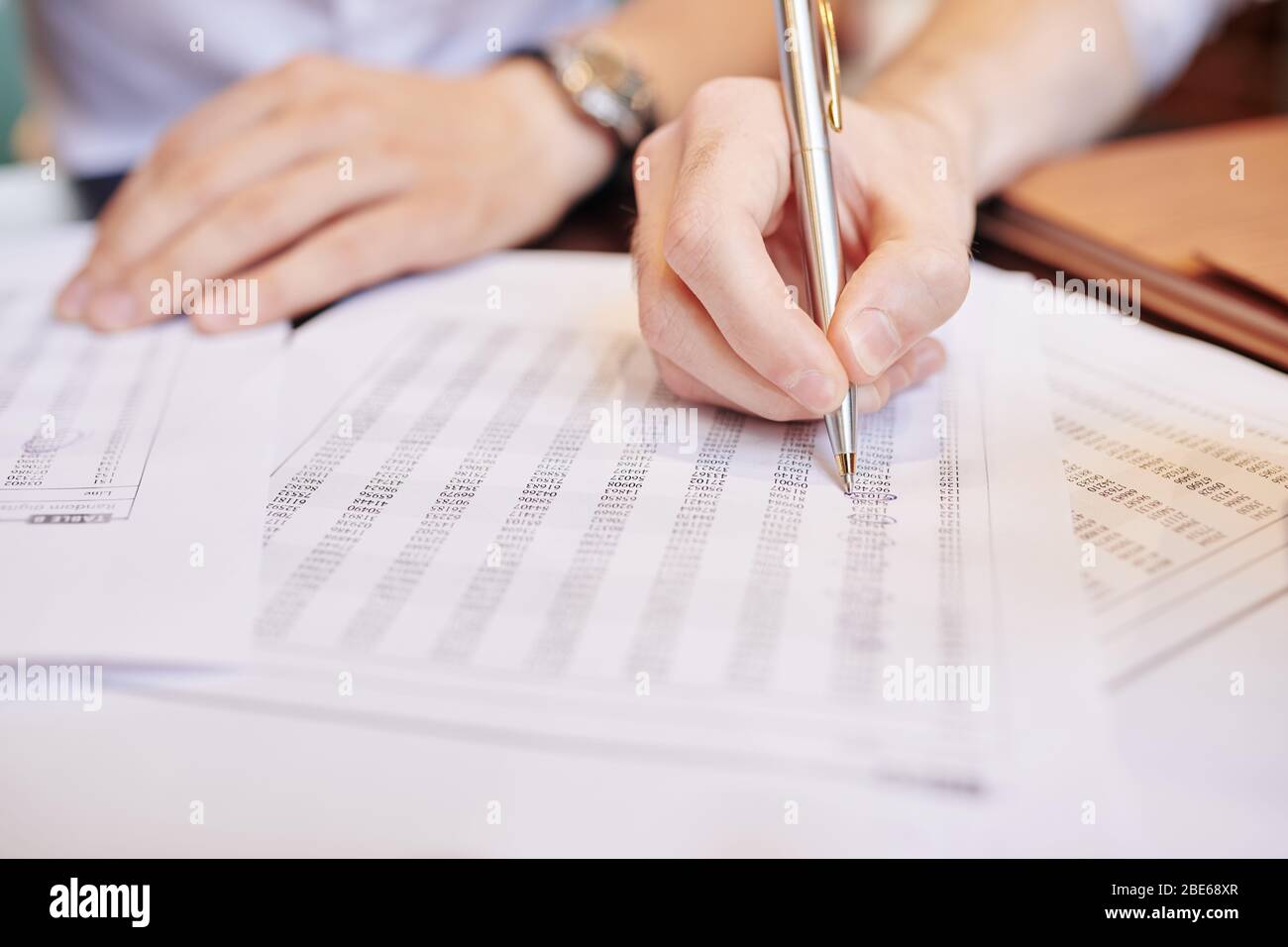 Close-up image of business people analyzing document with figures and ...