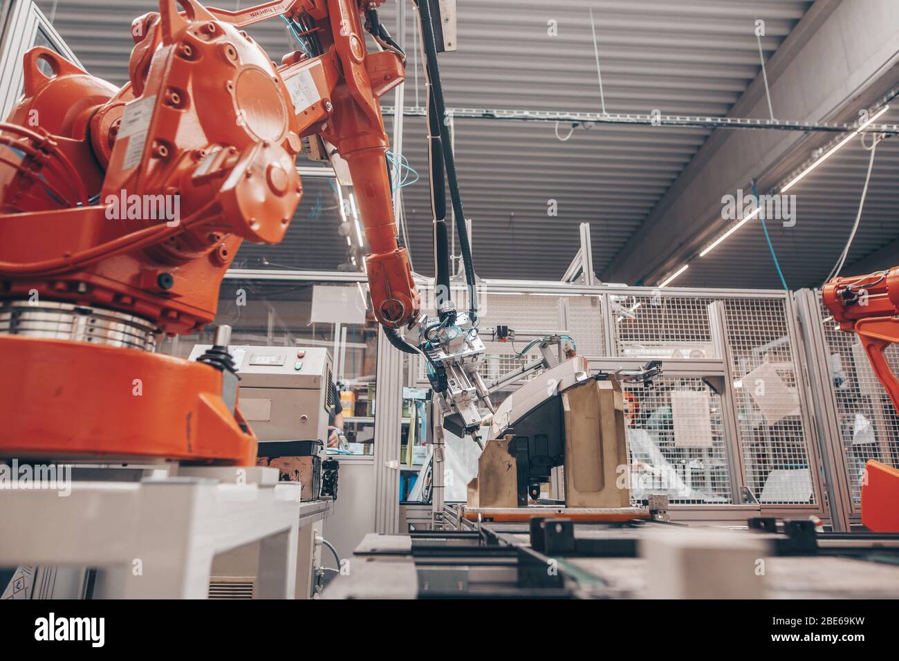 Close up of automatic robot arms in automotive industry, factory production of headlamps for a ...