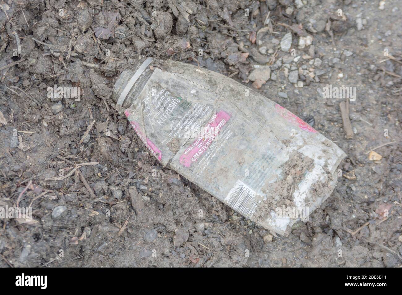 Empty soft drinks bottle on tarmac of a quiet country road. Example of ...