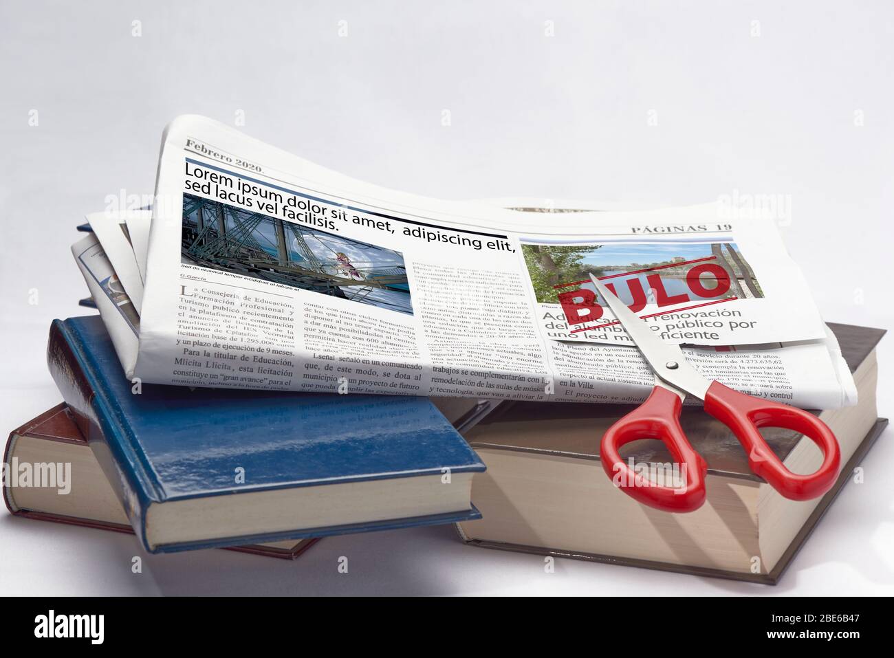 Stack of books and newspaper cutting fake news with scissors. Isolated ...